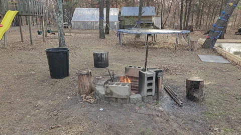 Wood being burn in deep fire pit made fr... | Stock Video | Pond5