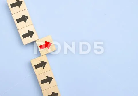 Wooden block with red arrow facing the opposite direction black arrows ...