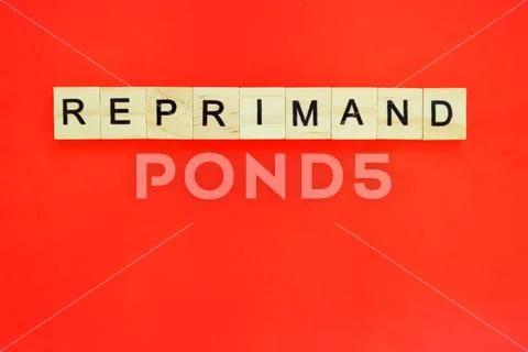 Photograph: Word reprimand. Top view of wooden blocks with letters on ...
