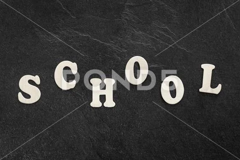 Photograph: The word School made with wooden letters on a black ...