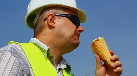 Worker eating ice cream on a blue sky ba... | Stock Video | Pond5