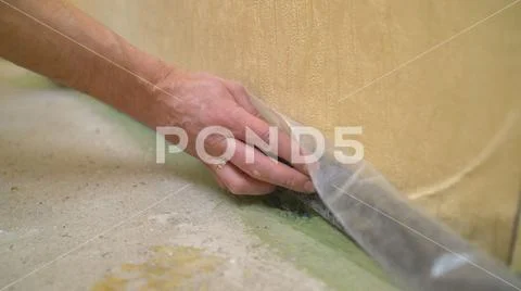 Worker glues damper tape before laying the floor. Reinforcing tape for ...