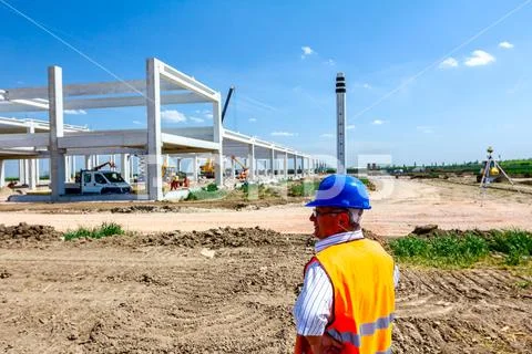 Worker is holding leveling rod to measuring level on construction site ...
