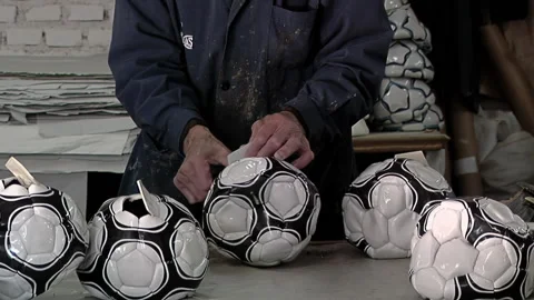 Worker Inserting a Football Bladder into... | Stock Video | Pond5