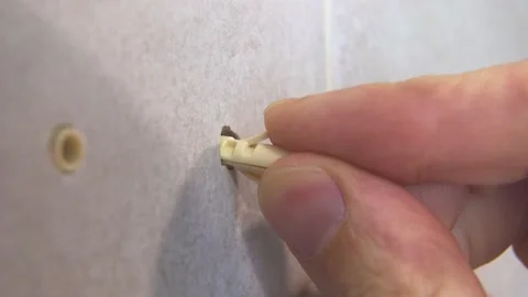 worker's hand inserts a plastic dowel pi... | Stock Video | Pond5