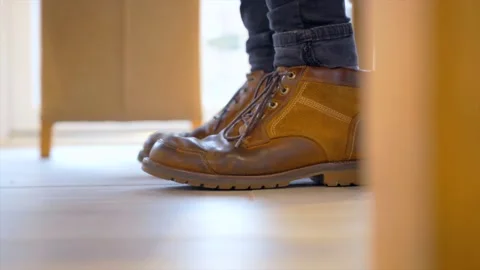 Worn mens brown boots tapping on the flo... | Stock Video | Pond5