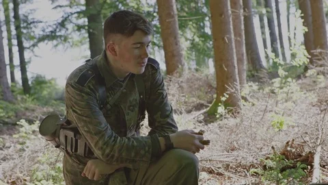 WW2 – A young soldier eating in forest | Stock Video | Pond5