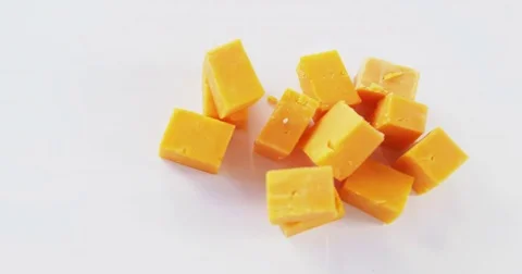 Yellow cheese cubes on white background | Stock Video | Pond5