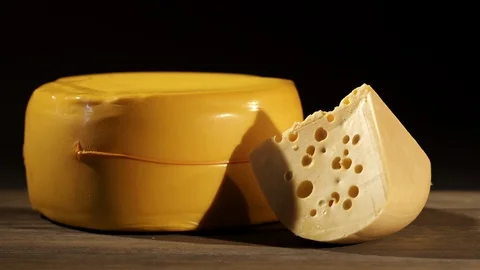 Yellow cheese wheel with wedge of Swiss ... | Stock Video | Pond5