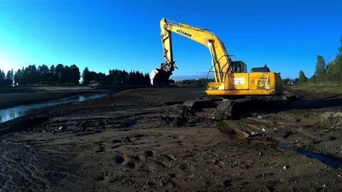 Yellow Excavator Moves Through the Mud a... | Stock Video | Pond5