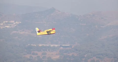 Yellow firefighter airplane flying throu... | Stock Video | Pond5