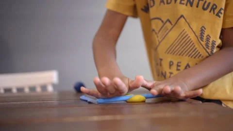 Yellow play dough being rolled by hands ... | Stock Video | Pond5