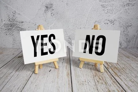 Photograph: Yes or No text message and alarm clock on wooden background ...