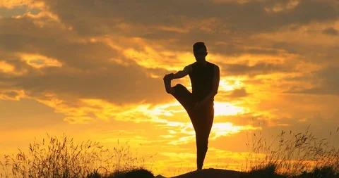 Yoga man stands on one foot balancing ou... | Stock Video | Pond5