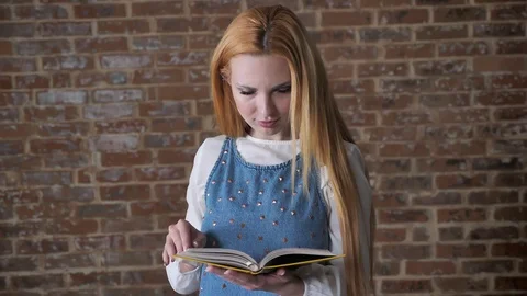 Young alluring blonde girl is reading bo... | Stock Video | Pond5