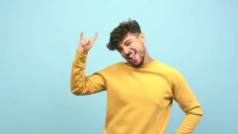 Young arab man doing a rock gesture, enj... | Stock Video | Pond5