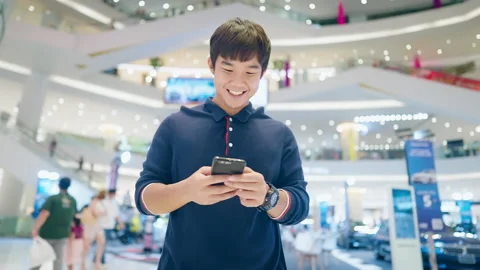 Young asian man look up on the phone for... | Stock Video | Pond5