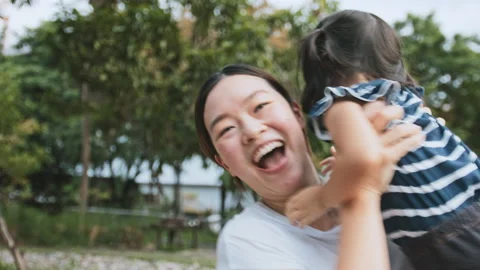 Young Asian mother lift cute daughter ki... | Stock Video | Pond5