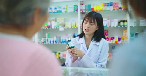 Young Asian pharmacist talking with cust... | Stock Video | Pond5