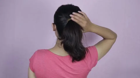 Young Asian woman untying her hair | Stock Video | Pond5