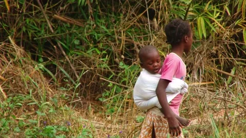 Young black girl carrying baby sibling o... | Stock Video | Pond5