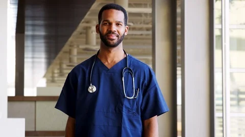 Young Black male doctor wearing scrubs | Stock Video | Pond5