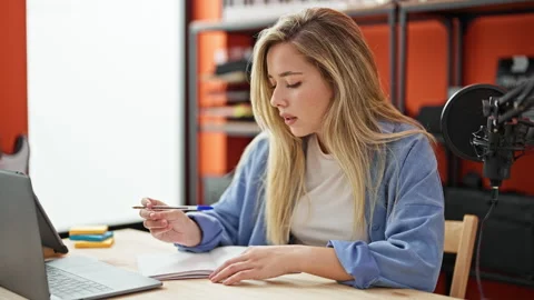 Young blonde woman musician writing song... | Stock Video | Pond5