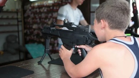 Young boy aiming with assault rifle in s... | Stock Video | Pond5