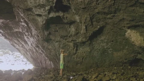 Young Boy Exploring A Small Cave - panni... | Stock Video | Pond5