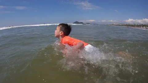 Young boy makes his way into ocean in ch... | Stock Video | Pond5