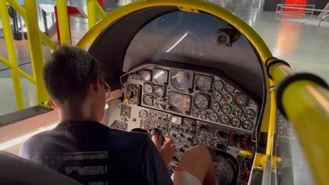 Young boy playing in fighter jet cockpit | Stock Video | Pond5