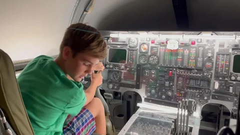 Young boy playing in fighter jet cockpit | Stock Video | Pond5