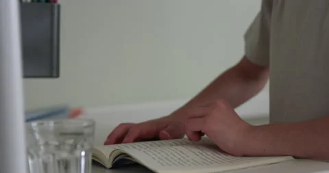 Young boy reading book at bedroom desk -... | Stock Video | Pond5