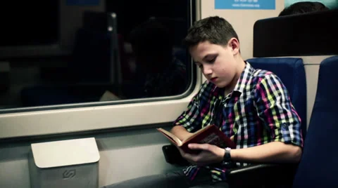 Young boy riding metro train and reading... | Stock Video | Pond5