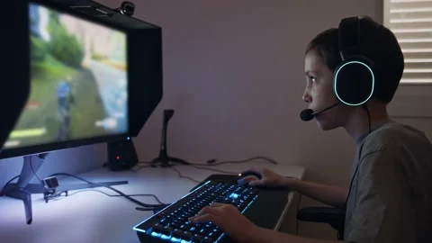 Young boy sitting in front of a computer... | Stock Video | Pond5