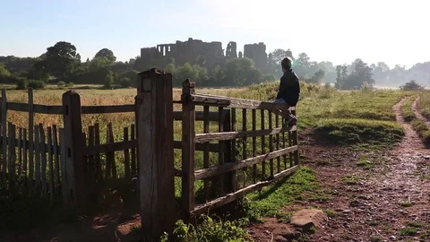 Young Boy Sitting On Gate Looking At Cas... | Stock Video | Pond5