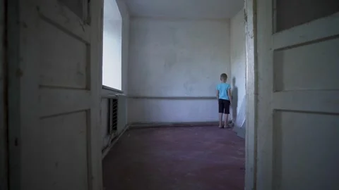 A young boy stands in the corner of an e... | Stock Video | Pond5