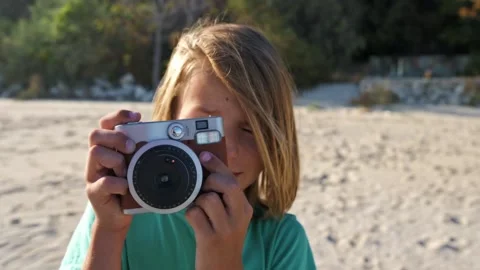 A young boy is using an instant camera t... | Stock Video | Pond5