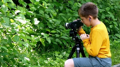 Young boy with video camera shoots film ... | Stock Video | Pond5