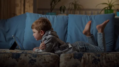 Young boy watching tablet computer layin... | Stock Video | Pond5