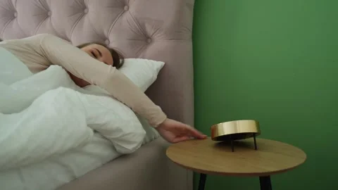 A young brunette woman wakes up in bed a... | Stock Video | Pond5