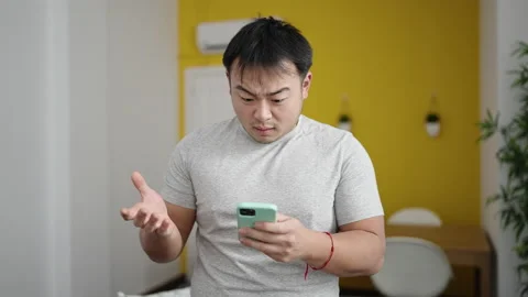 Young chinese man using smartphone stand... | Stock Video | Pond5