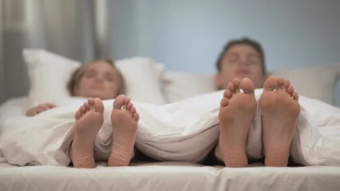 Young couple touching each other feet an... | Stock Video | Pond5