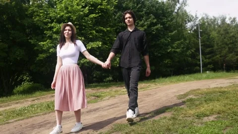A young couple walks along the edge of t... | Stock Video | Pond5