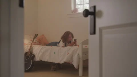 Young Curly-Haired Girl Lays on Her Bed ... | Stock Video | Pond5
