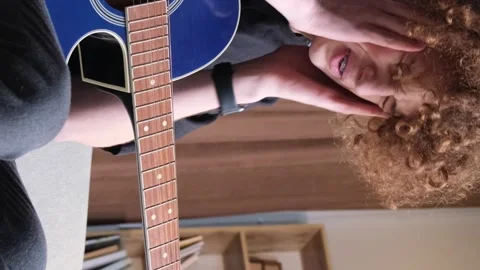 A young curly-haired musician with a gui... | Stock Video | Pond5