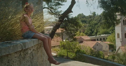 Young cute teenage girl sitting in the g... | Stock Video | Pond5