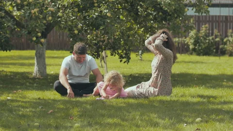 A young family on the grass in the garde... | Stock Video | Pond5
