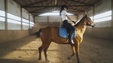 Young female rider trains riding a horse... | Stock Video | Pond5