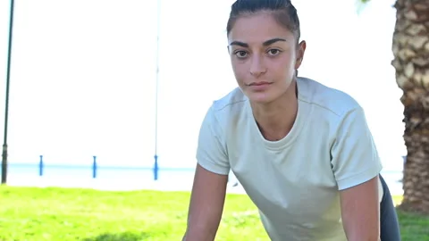 Young girl doing push-ups in the park | Stock Video | Pond5